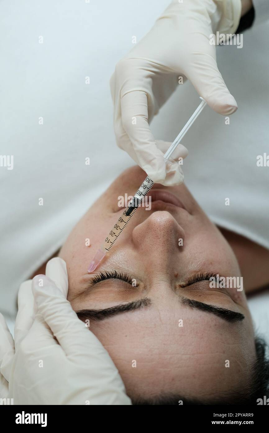 Cosmetologist applying eye mesotherapy to female patient Stock Photo ...