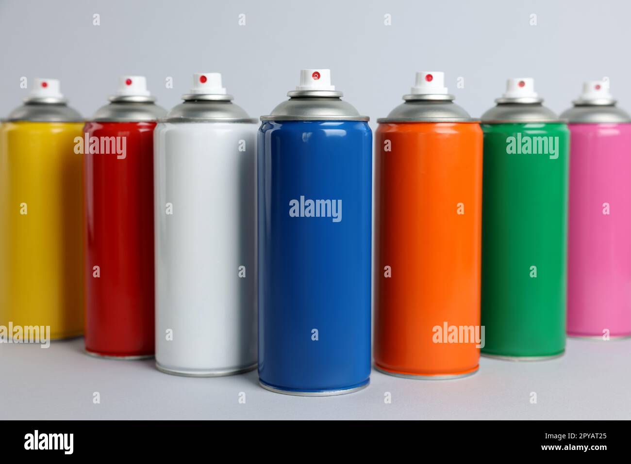 Colorful cans of spray paints on light grey background Stock Photo - Alamy