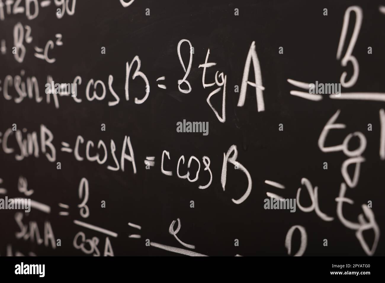 Different mathematical formulas written with chalk on blackboard ...