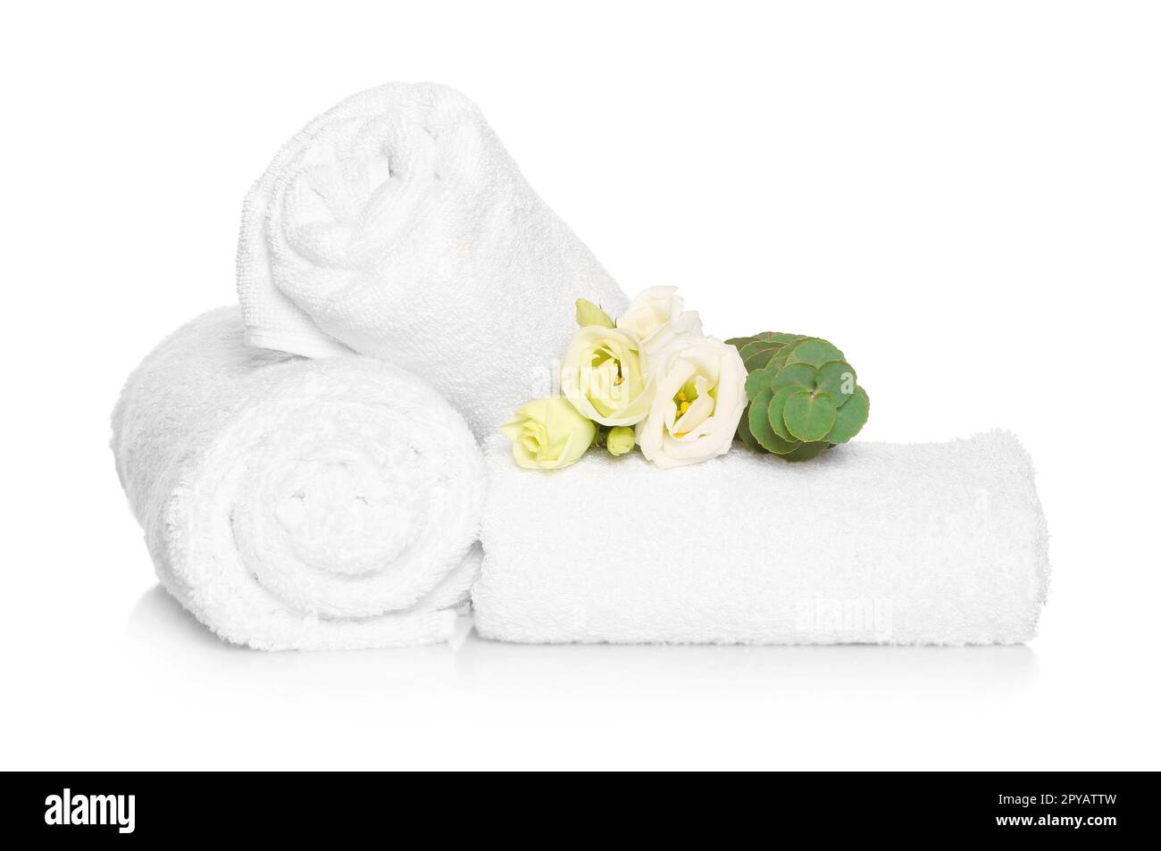 Soft terry towels with beautiful flowers and eucalyptus branch on white ...