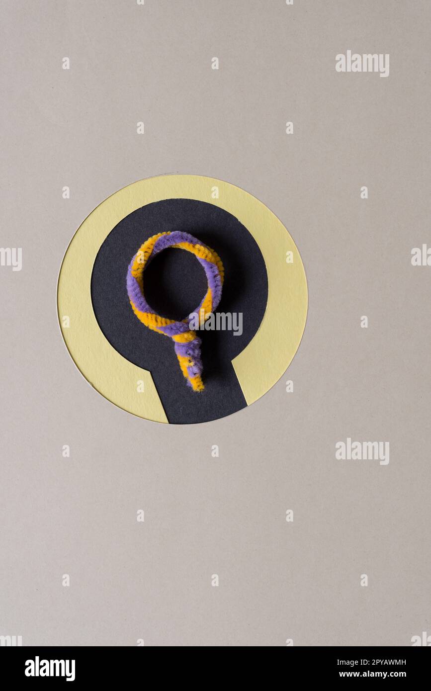 twisted pipe cleaner isolated on paper with overlay beige paper frame ...