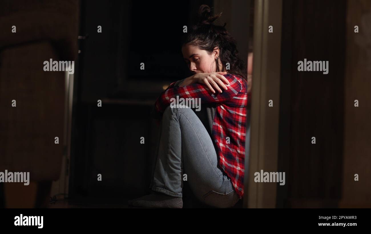 Depression and mental disorder. Young Caucasian woman sits down on ...