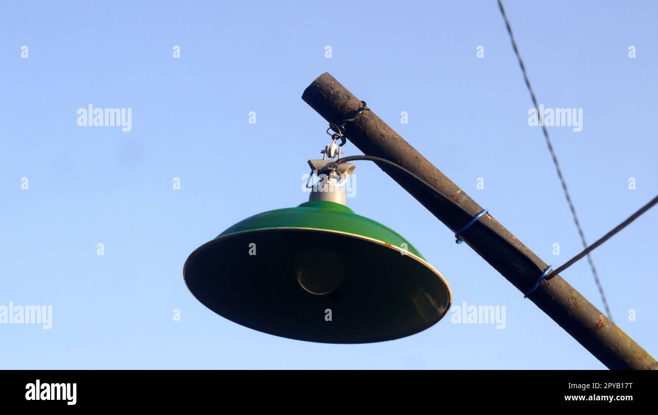 green street lights shot from below against a bright blue sky ...