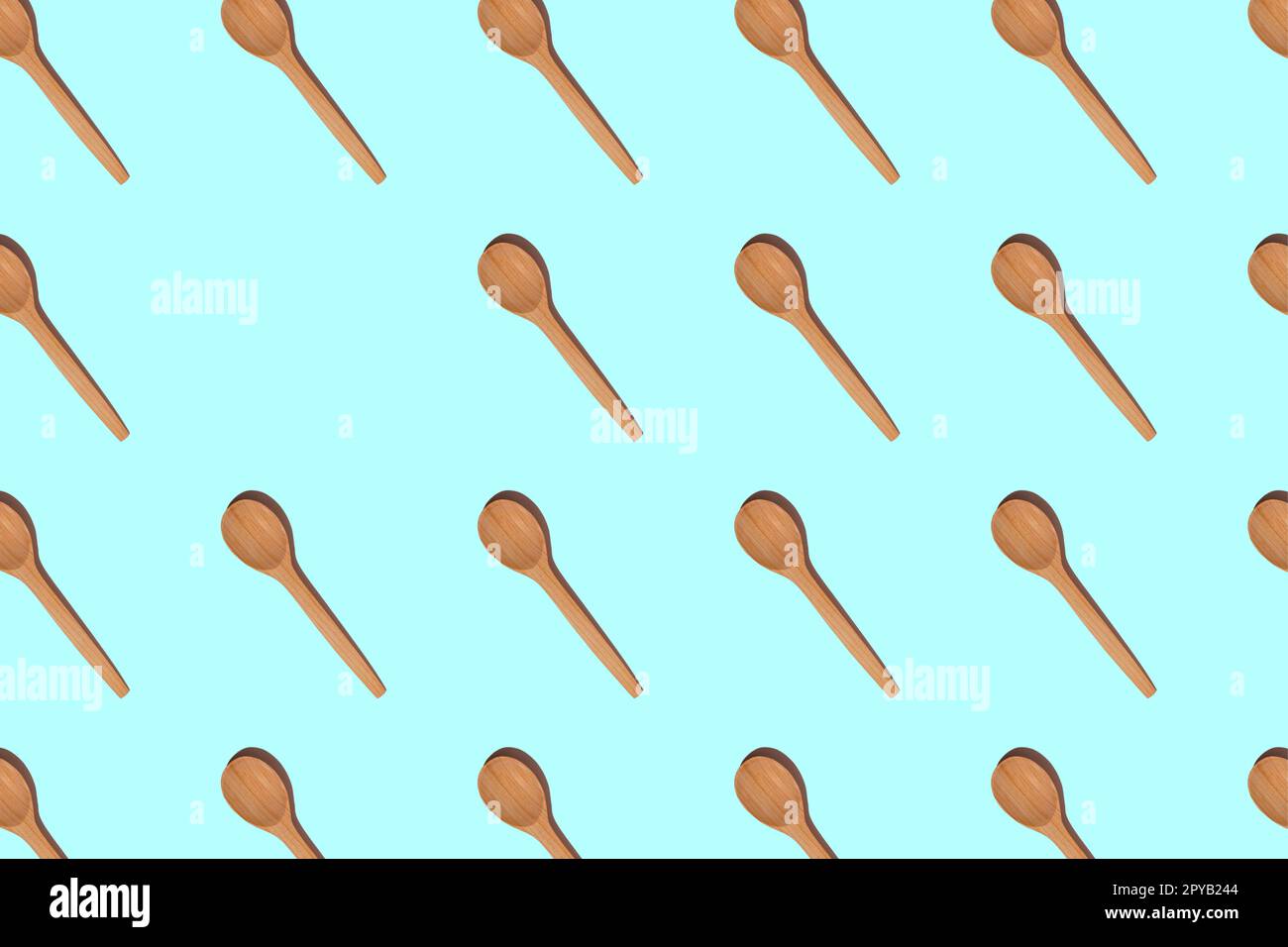 Pattern of wooden spoons with hard shadows isolated on light blue ...