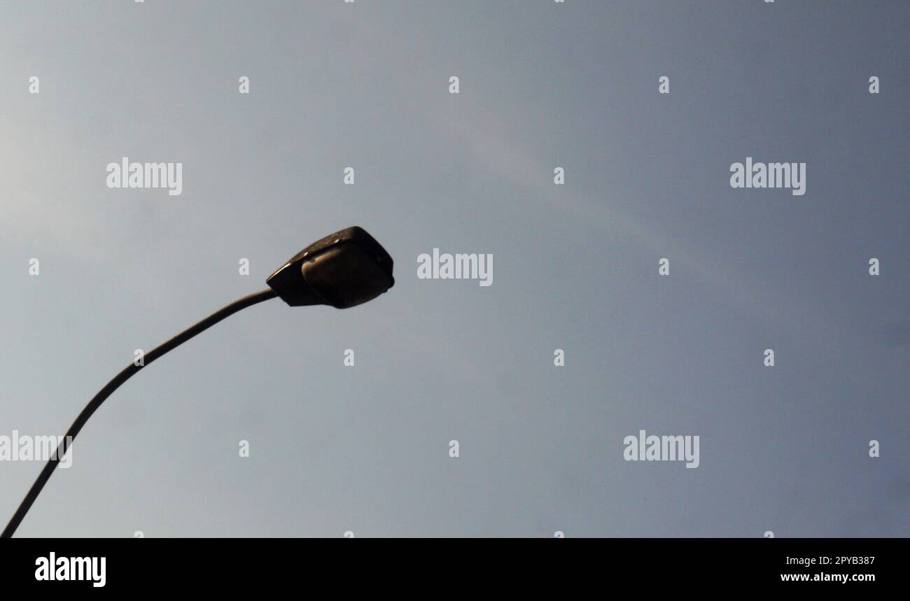 silhouette of a street lamp shot from below against a dark sky ...