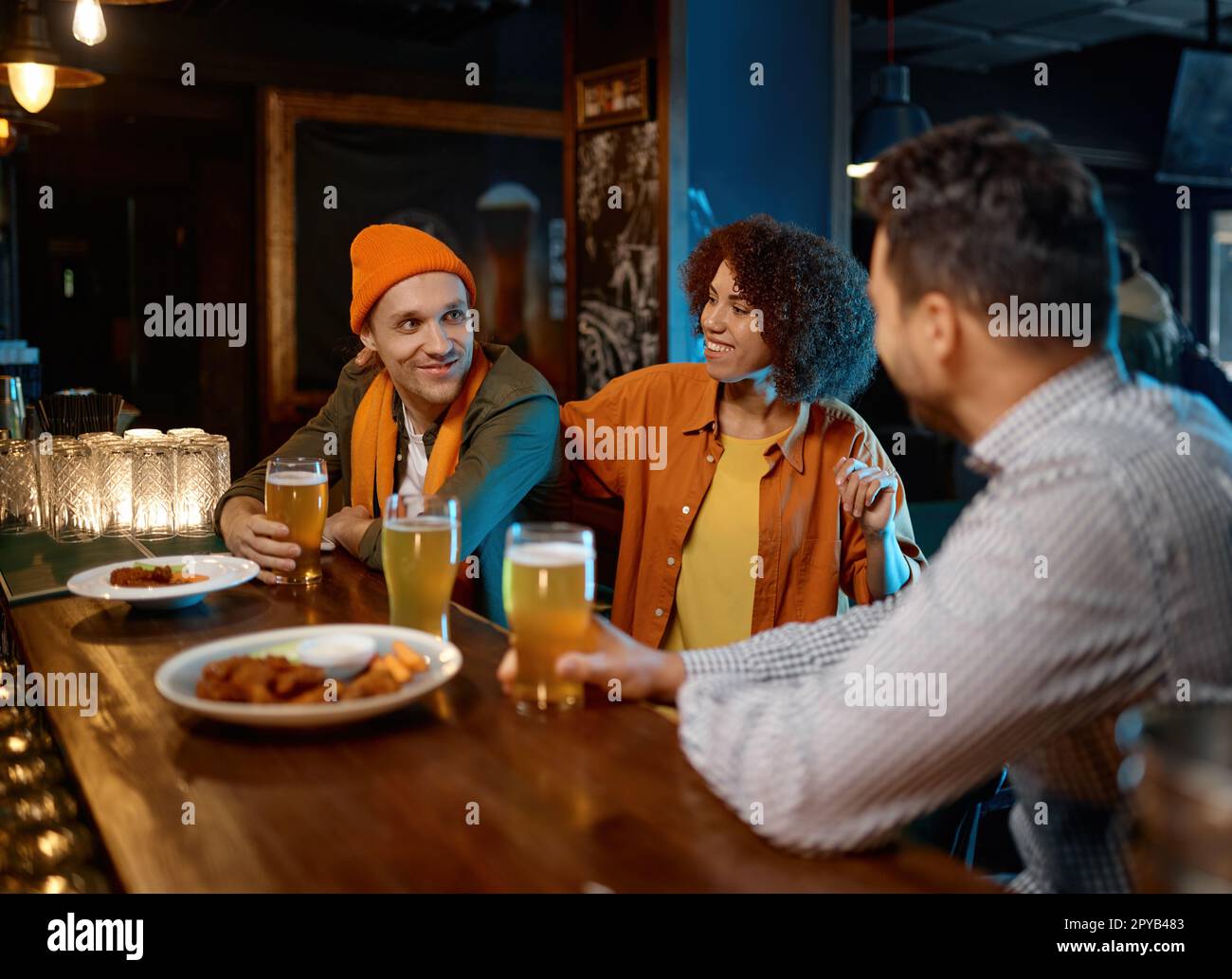 Group of young friends celebrating success while rest at sports bar ...