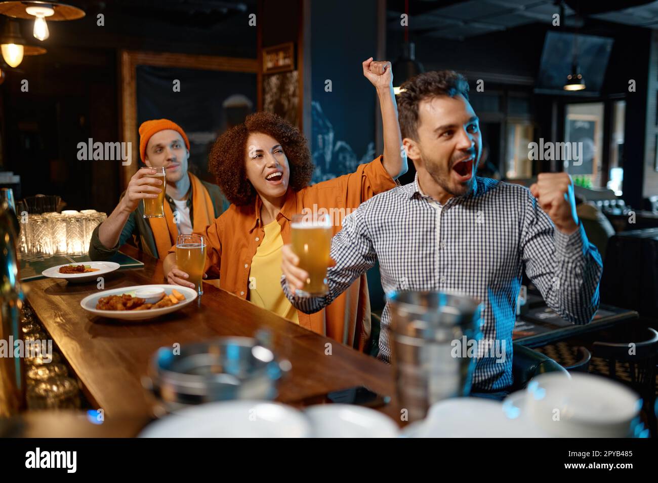 Excited football fans in the pub Stock Photo - Alamy