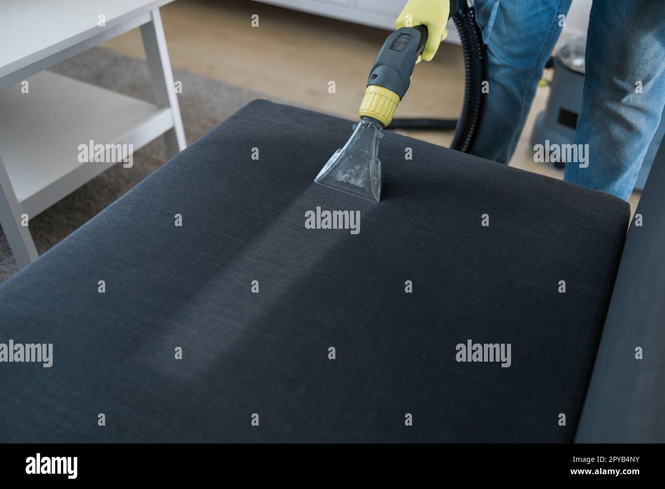 Man dry cleaner's employee hand in protective rubber glove cleaning ...