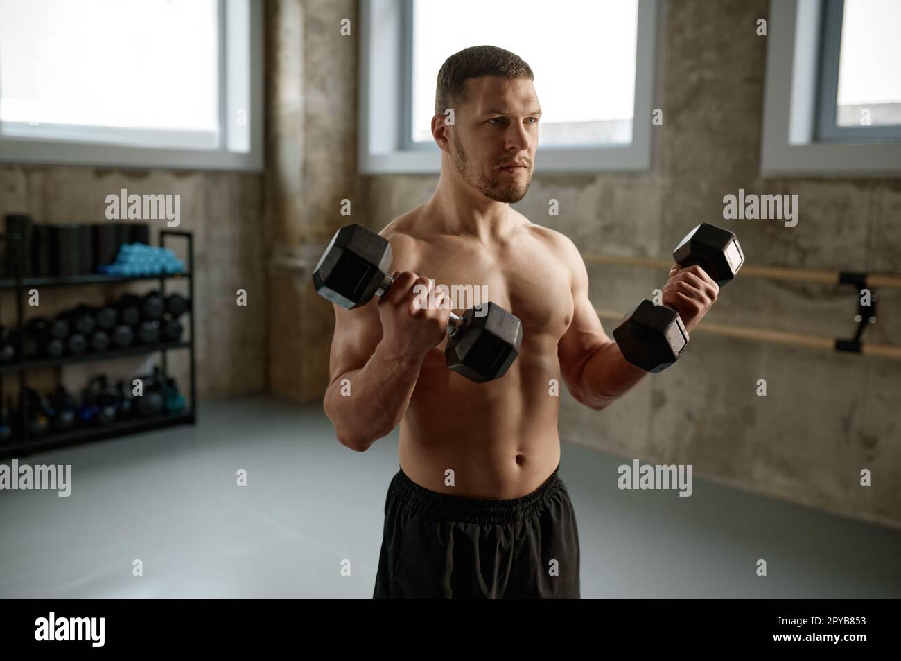 Sportive man workout with dumbbells in gym, strength and motivation ...