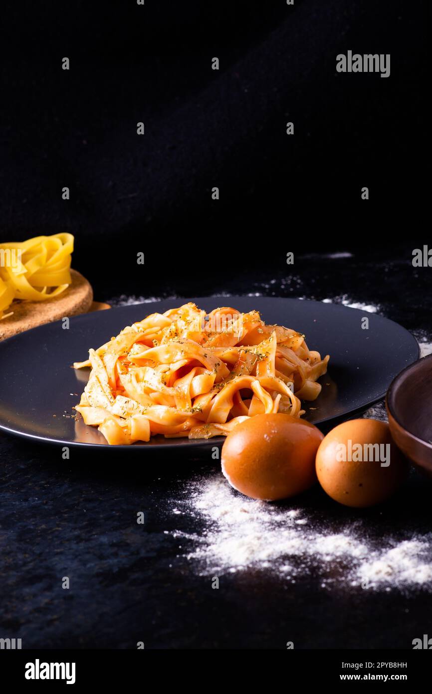 A close-up of hands holding a fork, digging into a plate of fast food ...