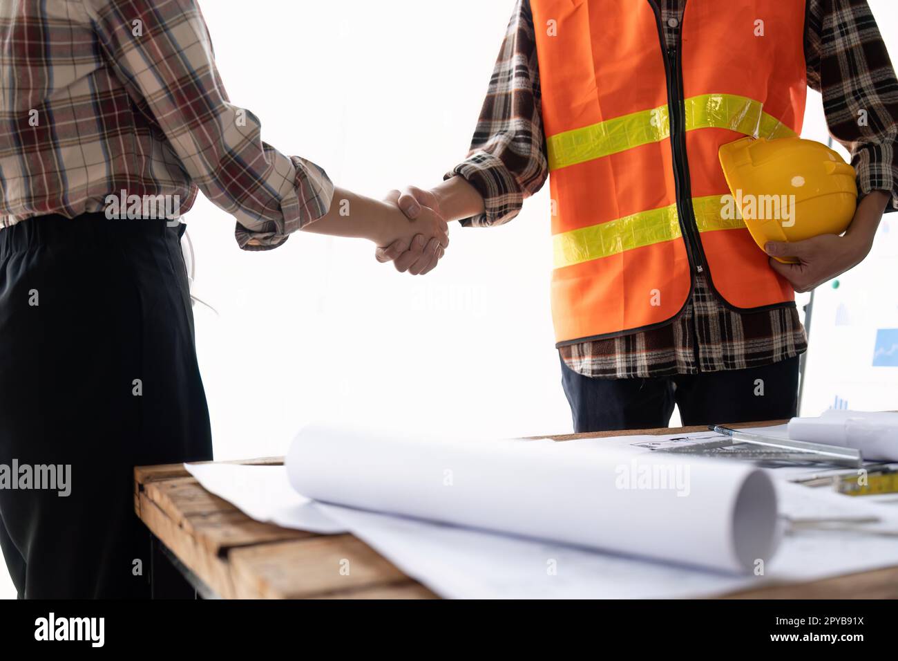 Architect and engineer construction workers shaking hands while working ...