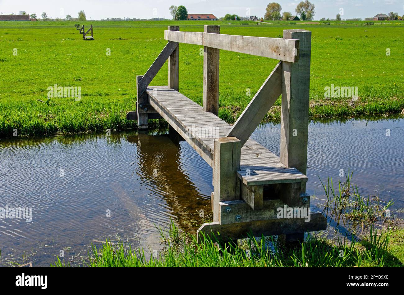 Simple wooden bridge across a ditch with several others in the distance ...
