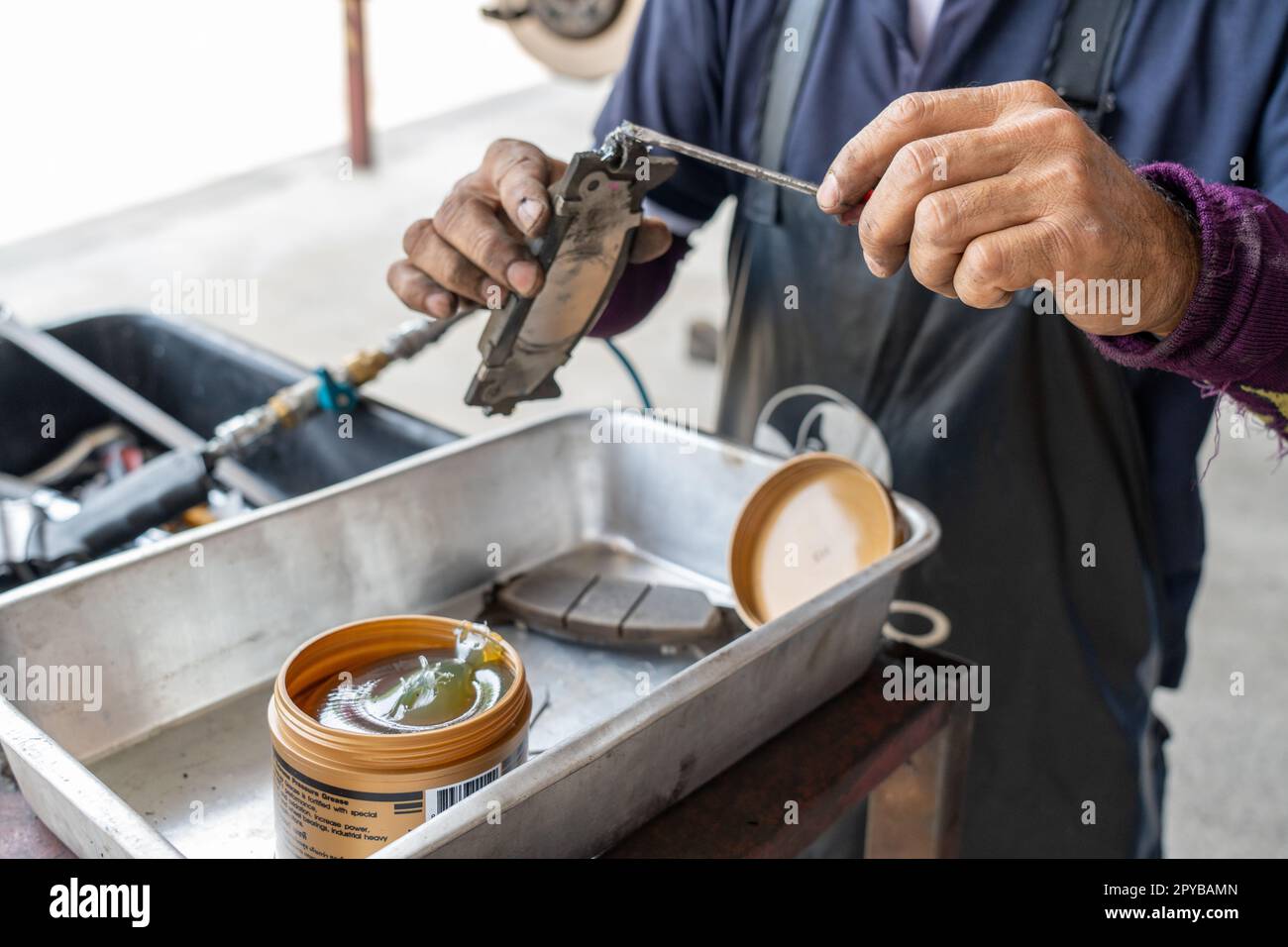 Auto mechanic putting lubricating grease oil on the break shoe before ...