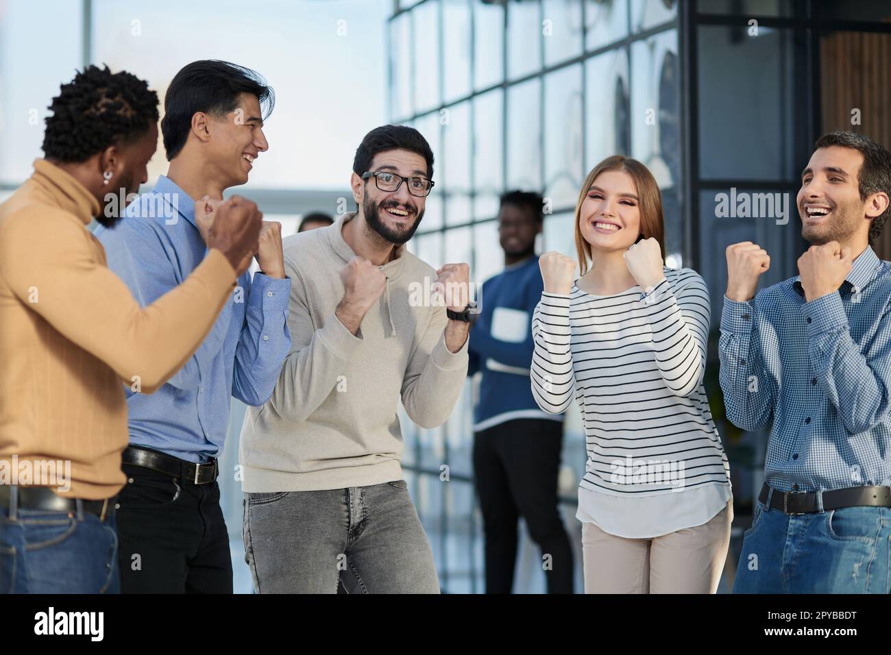 Business people celebrates and clench their fists in the air as a ...