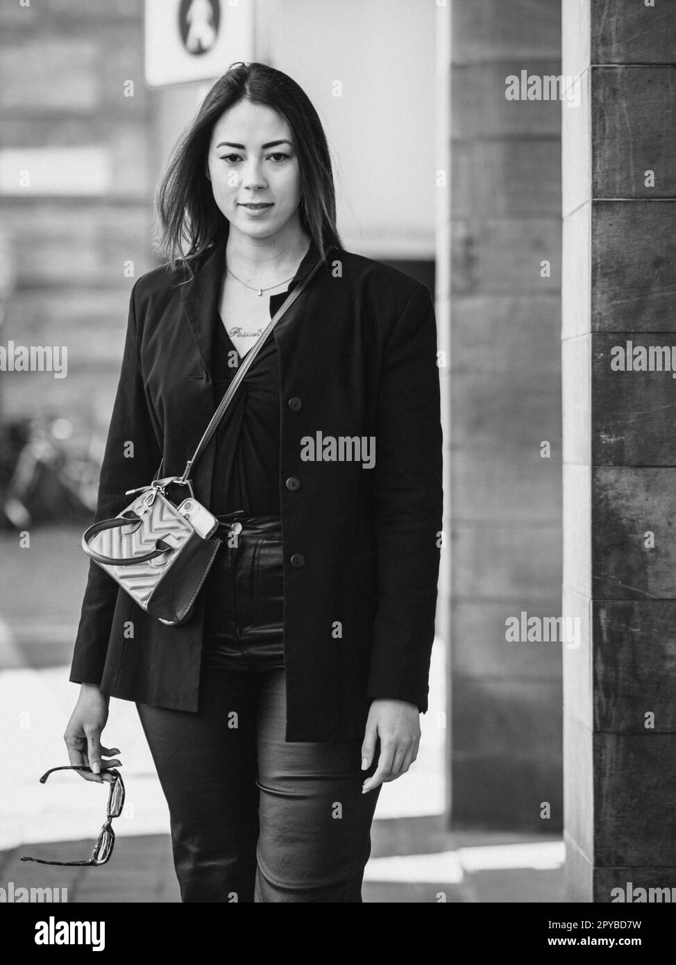 black and white street portrait of curvy brunette long haired standing ...