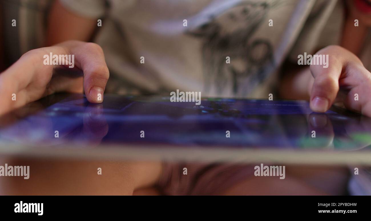 Kid hands holding tablet device. Closeup of child fingers touching ...