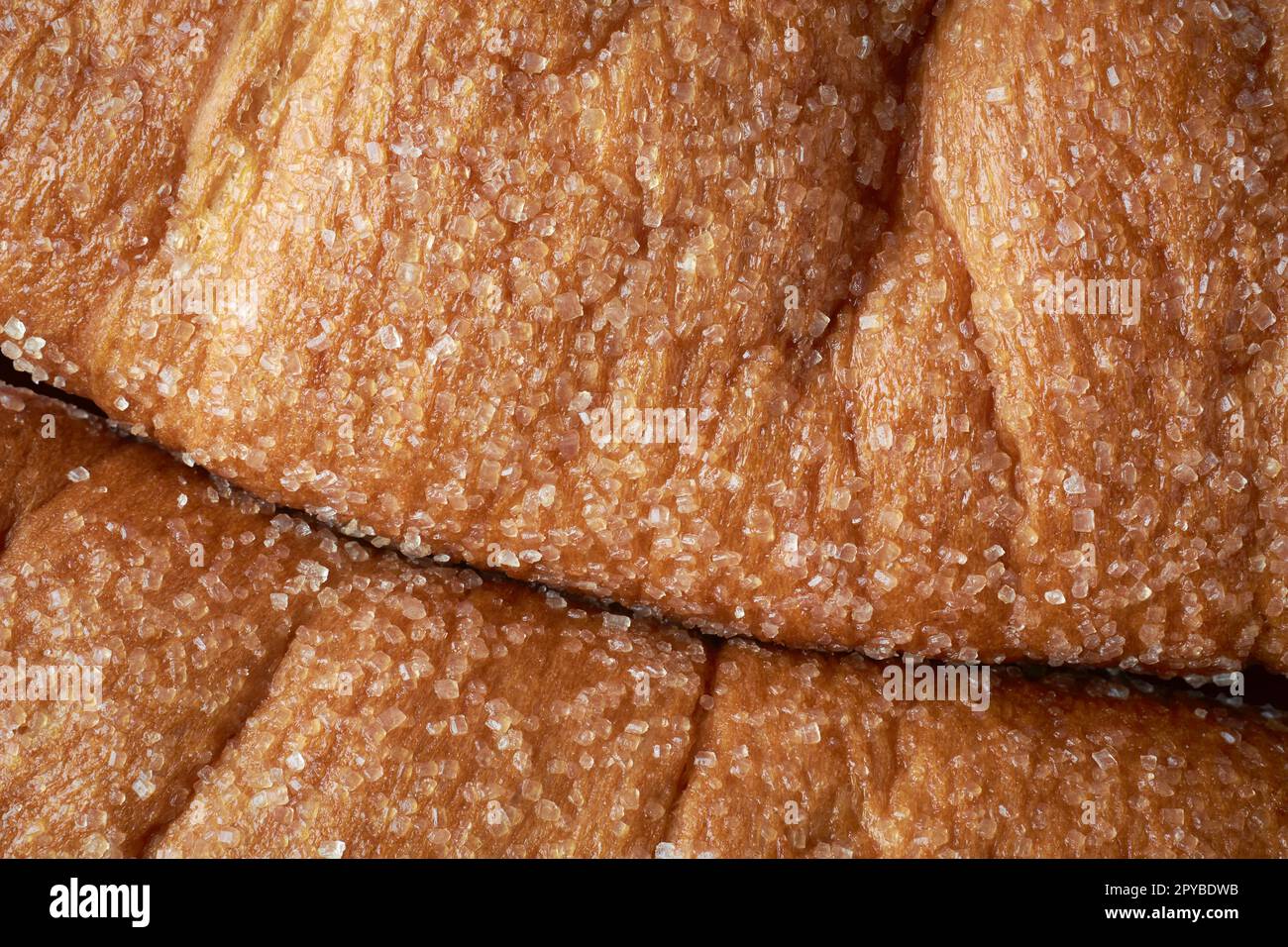 close-up macro view of surface of freshly baked sweet sugar coated bun ...