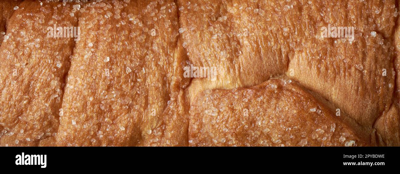 panoramic view of surface of freshly baked sweet sugar coated bun ...