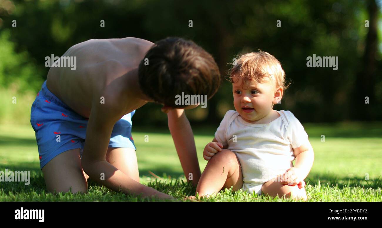 Older brother caring for baby sibling. Authentic family moment. Two ...