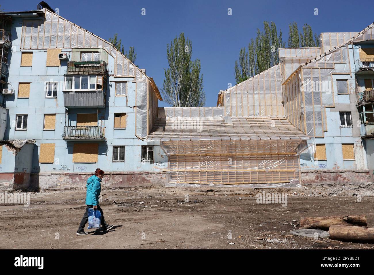 A woman walks past the preserved for reconstruction apartment building ...