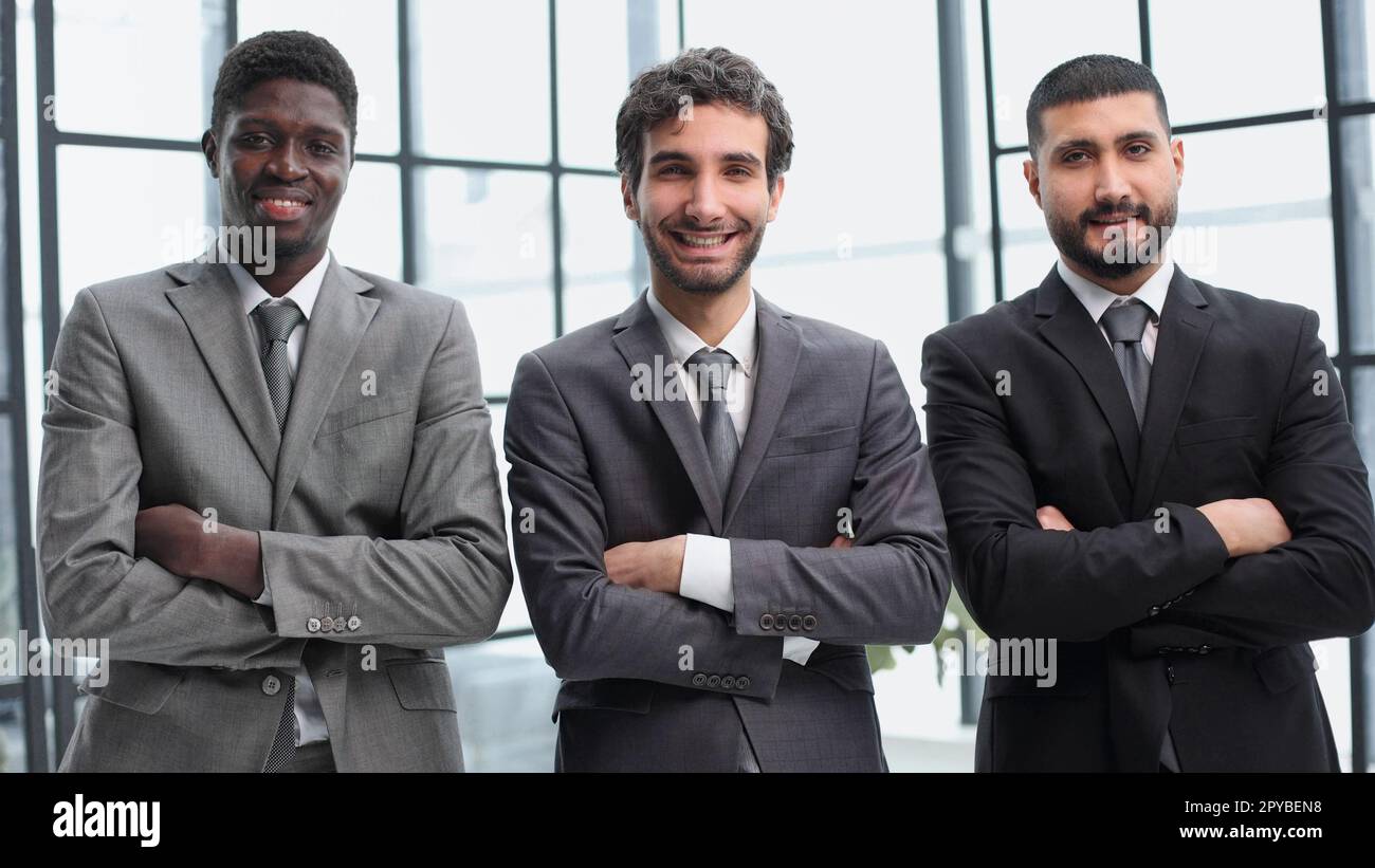 three businessmen crossing their arms looking at camera Stock Photo - Alamy
