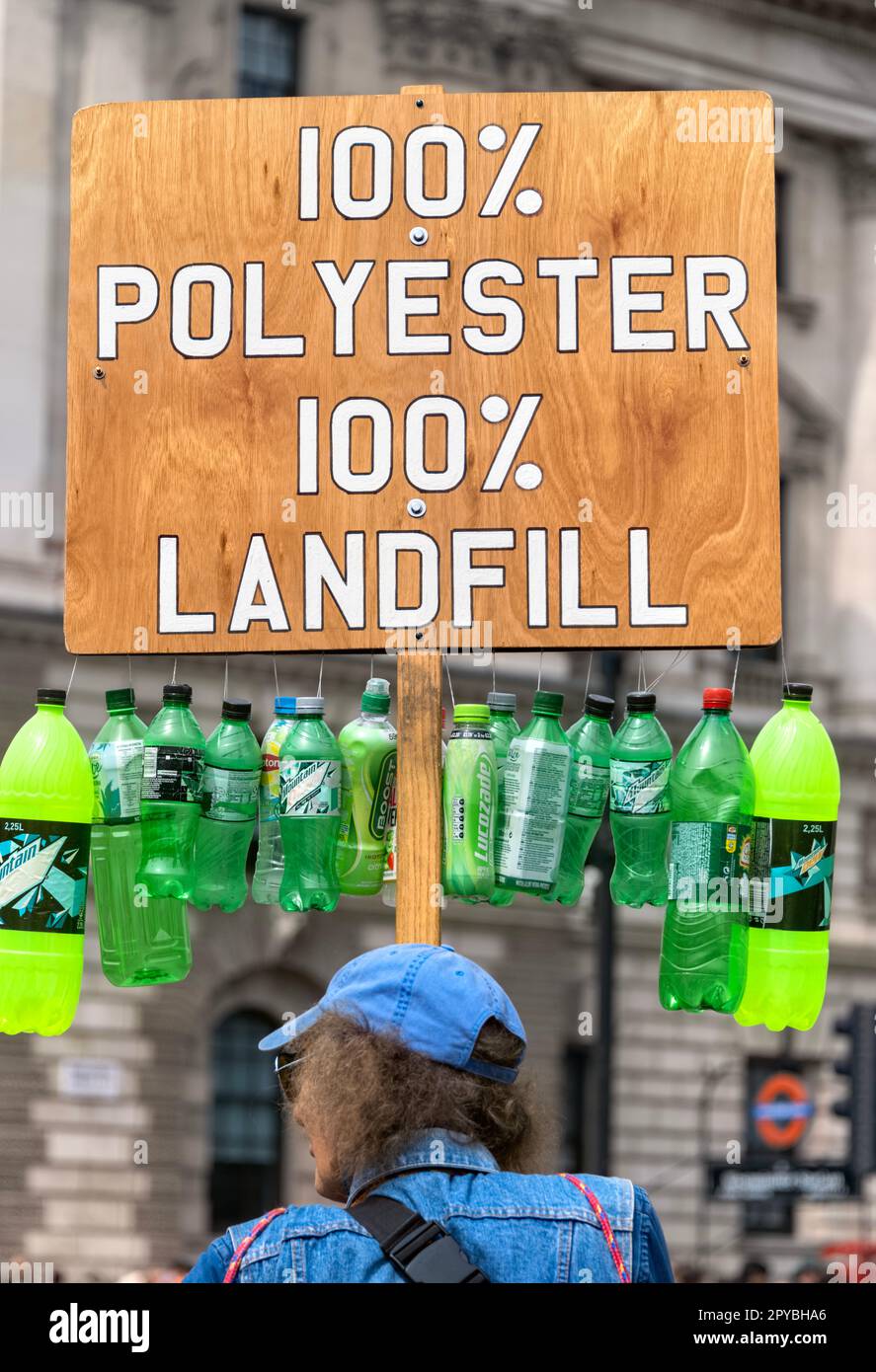Protester at Whitehall London holding up several plastic bottles ...