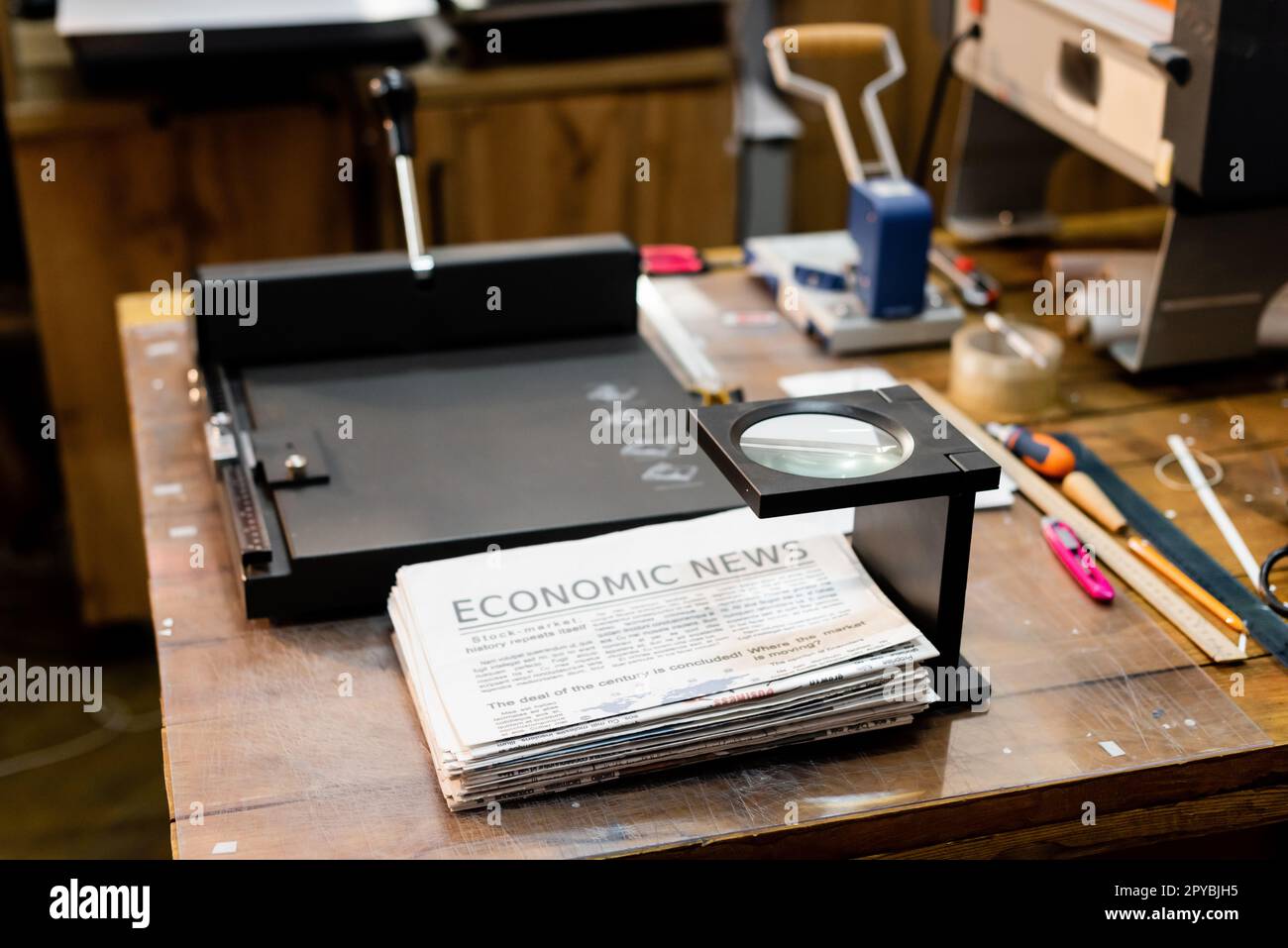 magnifying glass over newspapers with economic news and professional ...