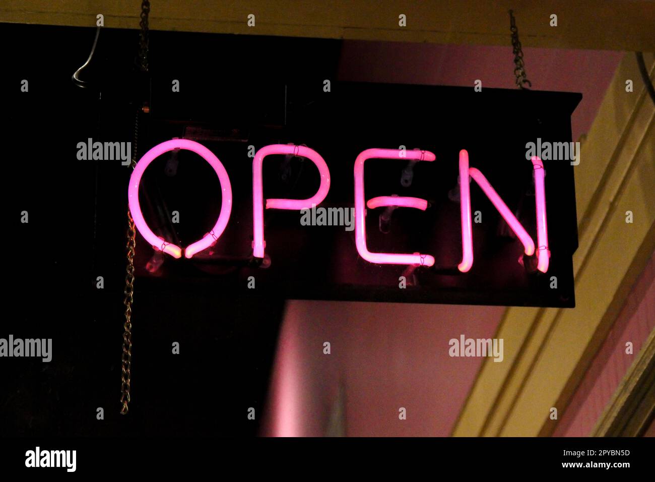 Open pink neon sign in a business window Stock Photo - Alamy