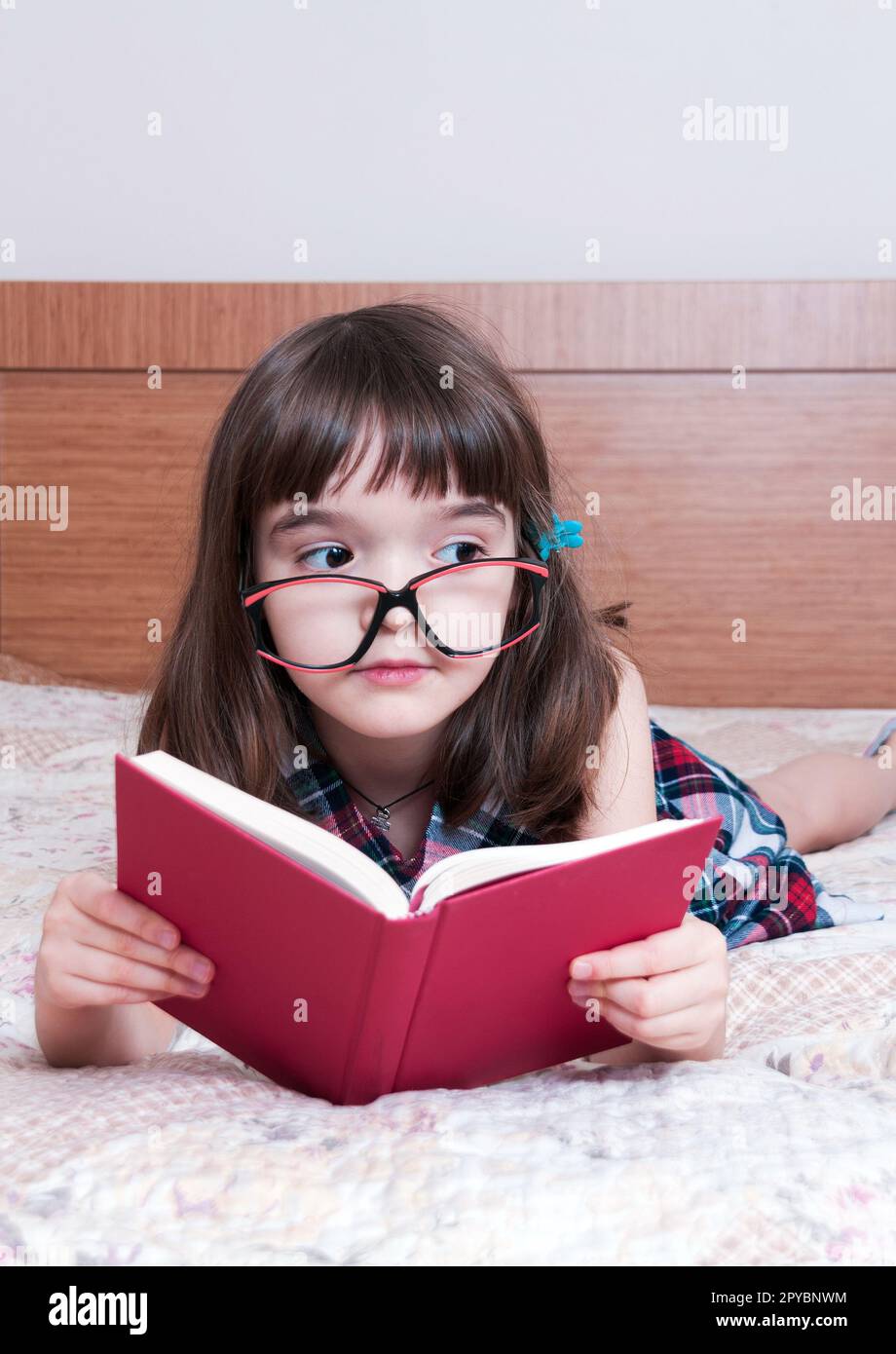Little girl reading a book at home Stock Photo - Alamy