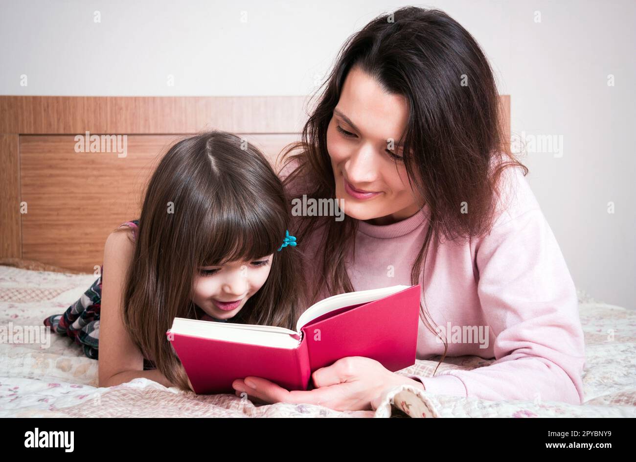 Mom with the daughter reading together Stock Photo - Alamy