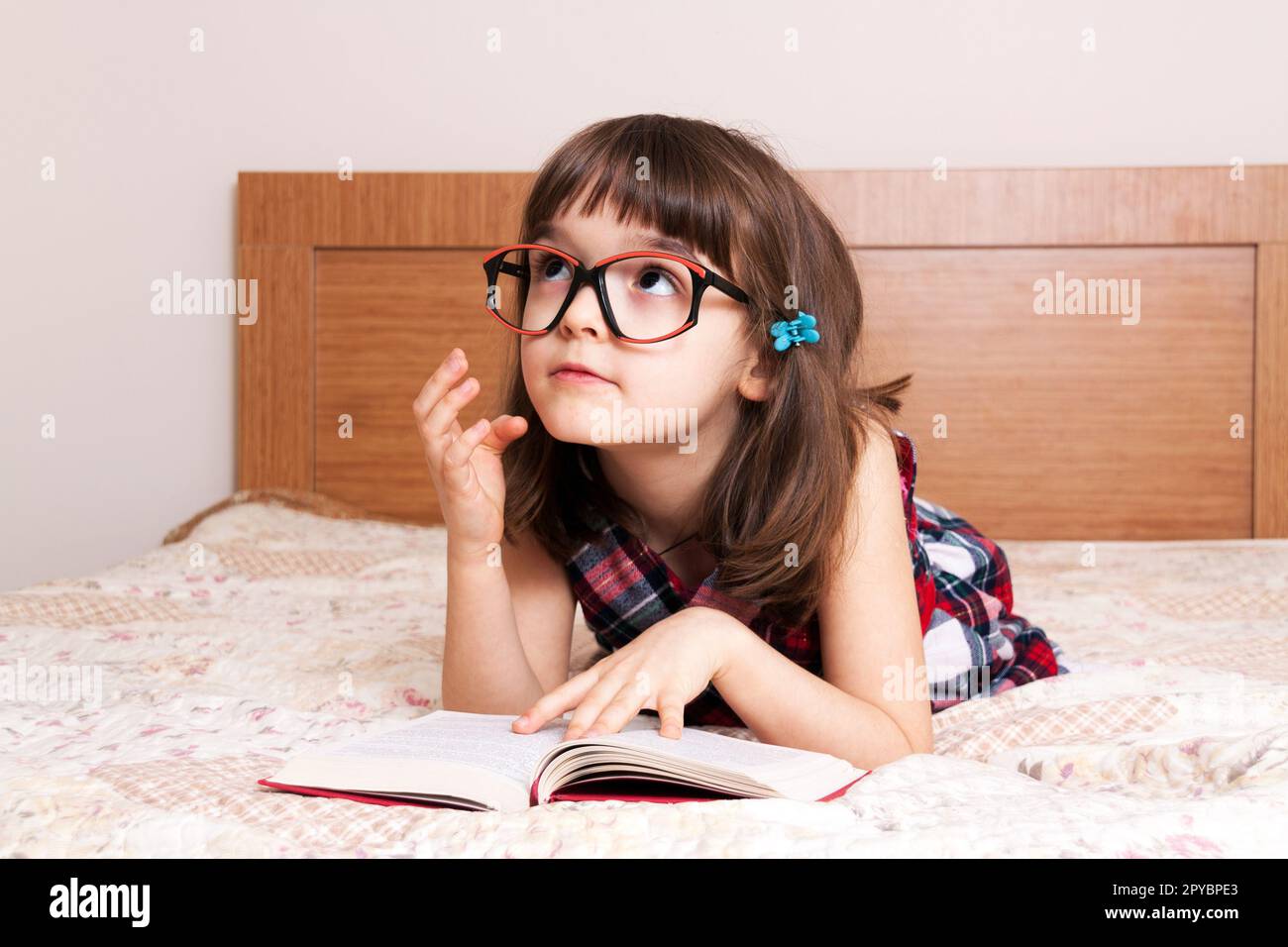Little girl reading a book at home Stock Photo - Alamy