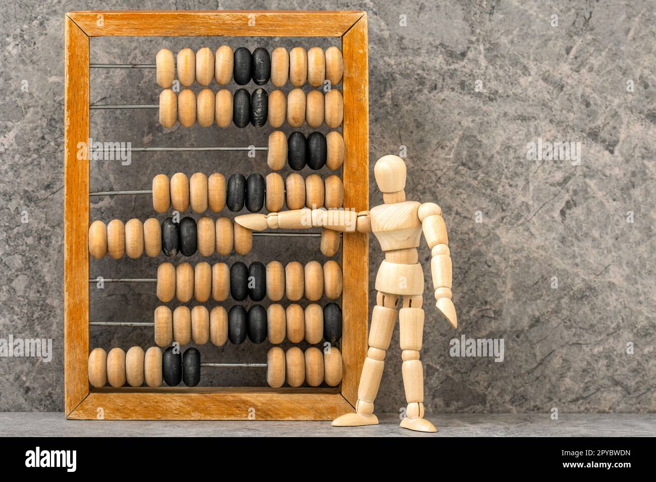Wooden man counting with old wooden abacus Stock Photo - Alamy