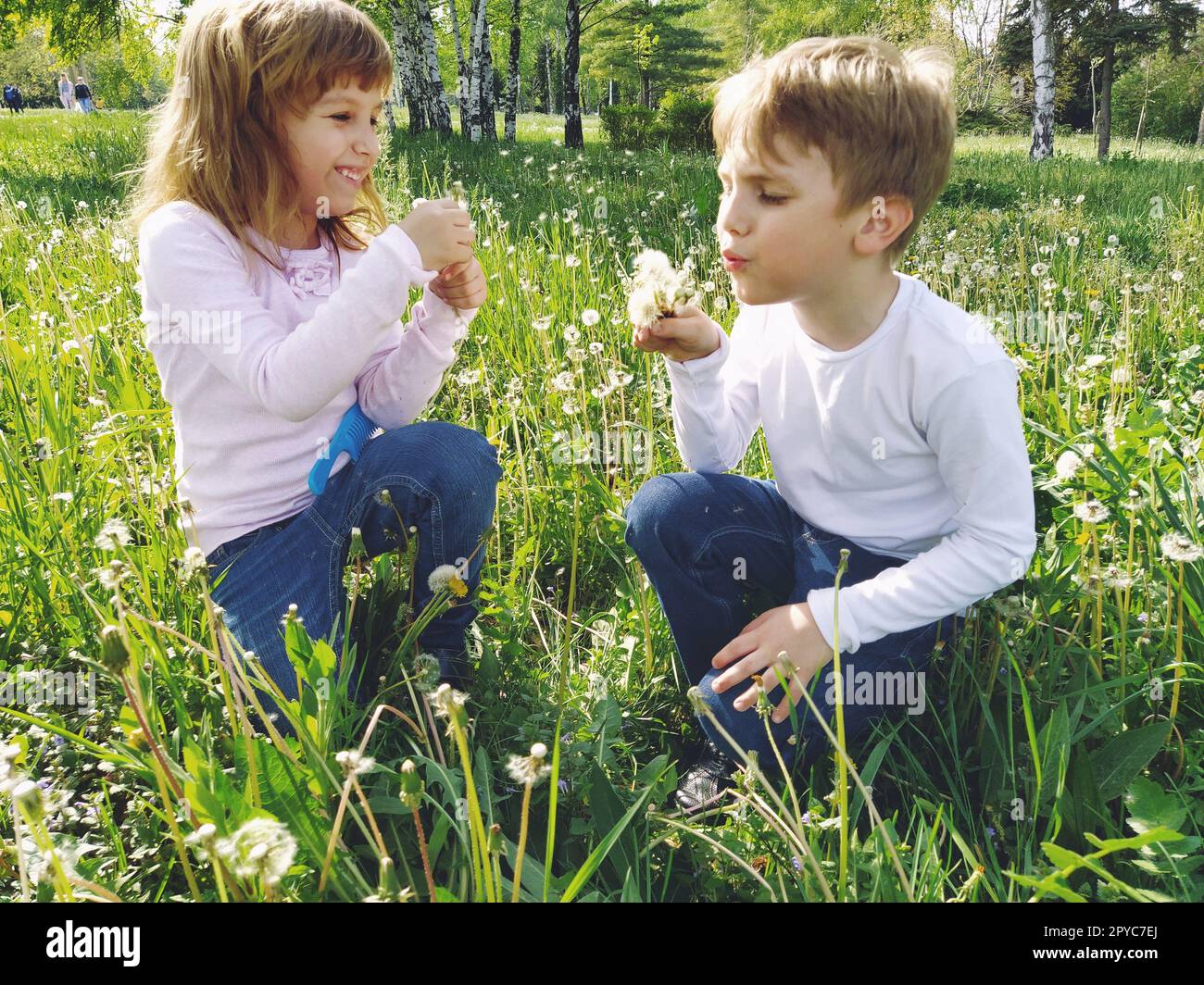 boy and girl in the meadow. Children play in nature. Spring or summer ...