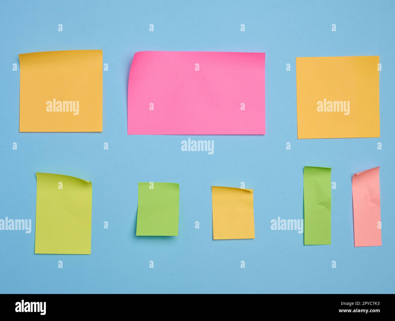 Colorful paper memo holders on blue background, space for writing data ...