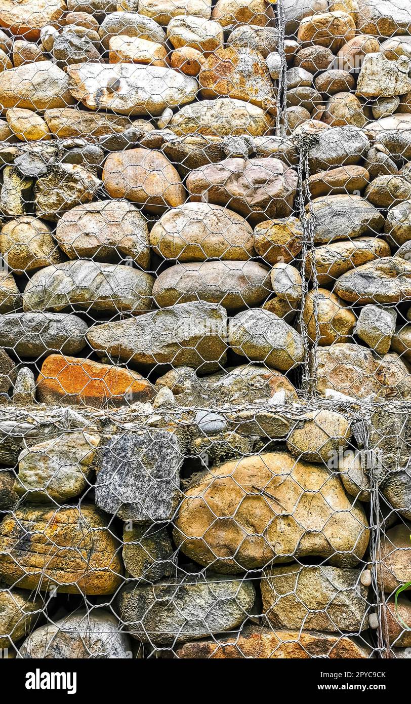 Stones rocks pinned behind a net in Mexico Stock Photo - Alamy