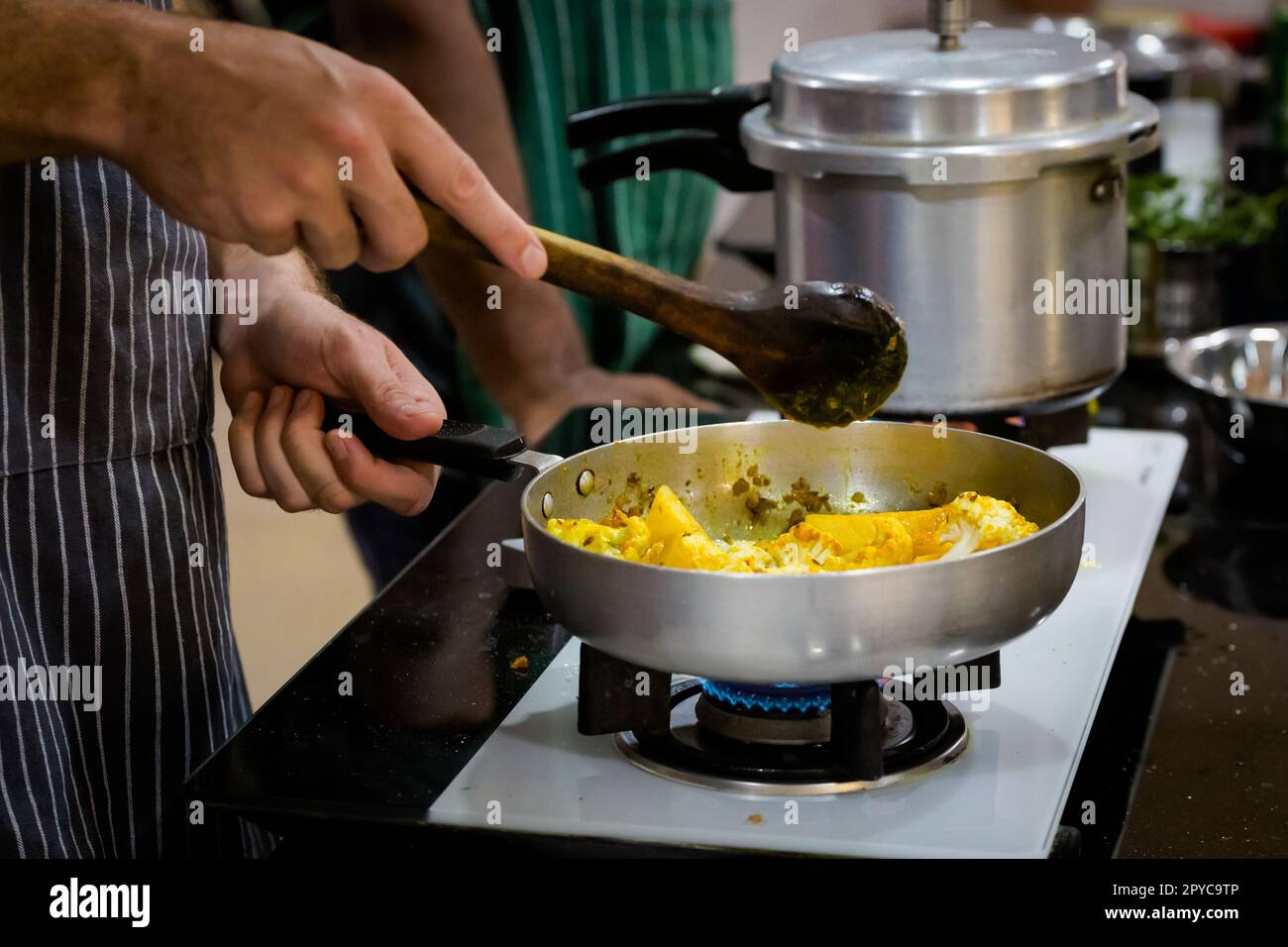 Traditional way of preparing indian food aloo gobi (potatoes with ...