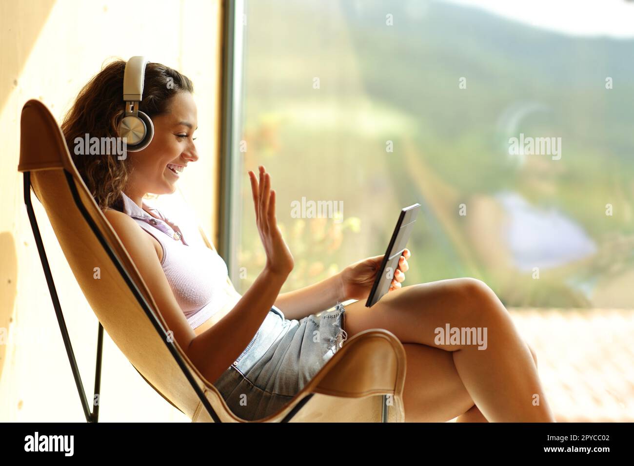 Woman on a chair having a video call Stock Photo - Alamy