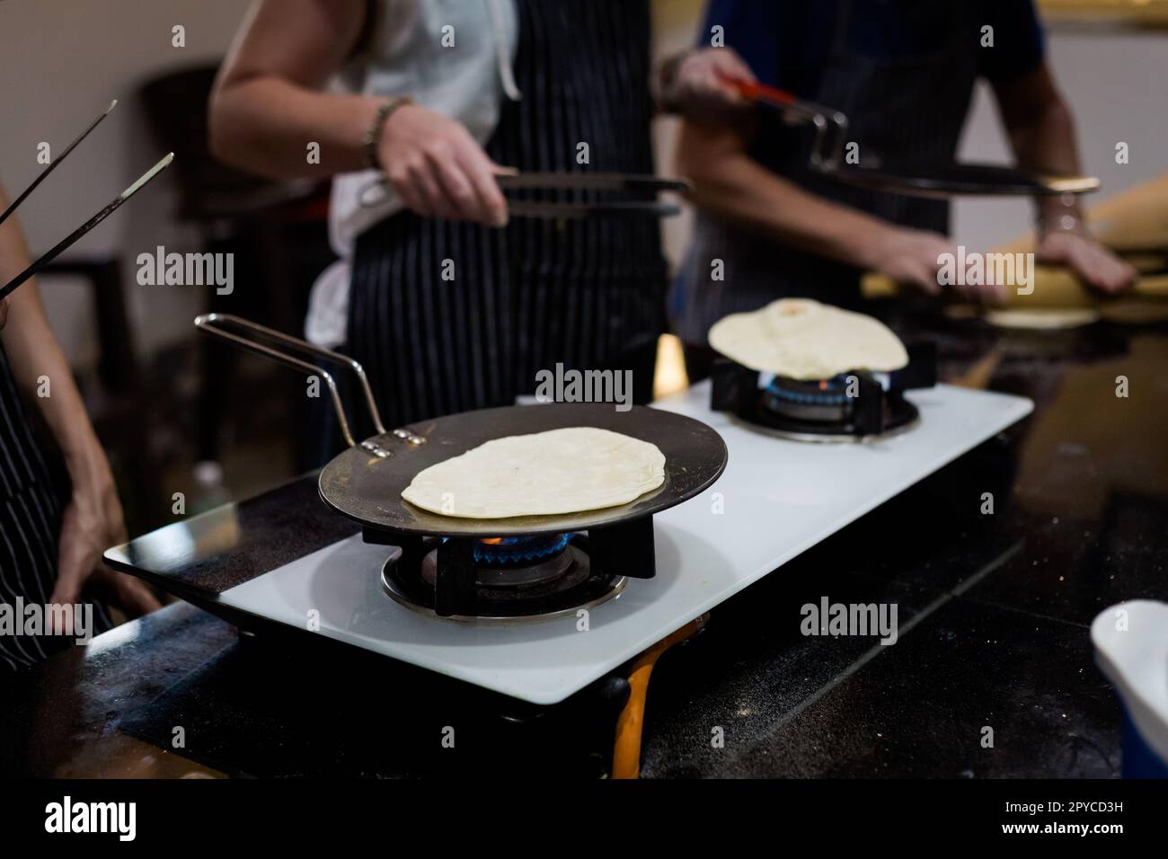 Traditional way of preparing indian food, making roti bread. Picture of ...