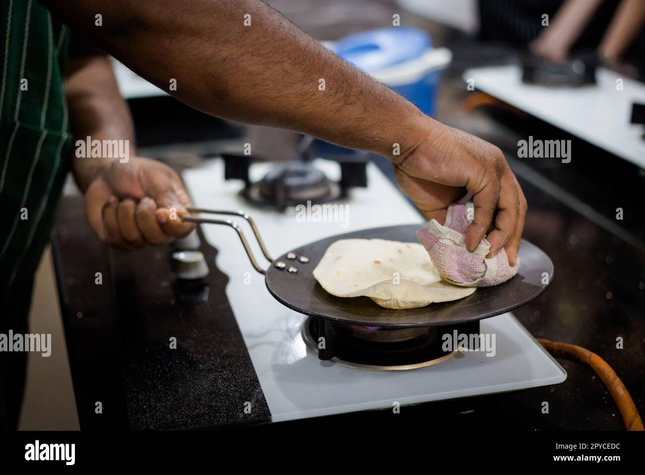 Traditional way of preparing indian food, making roti bread. Picture of ...