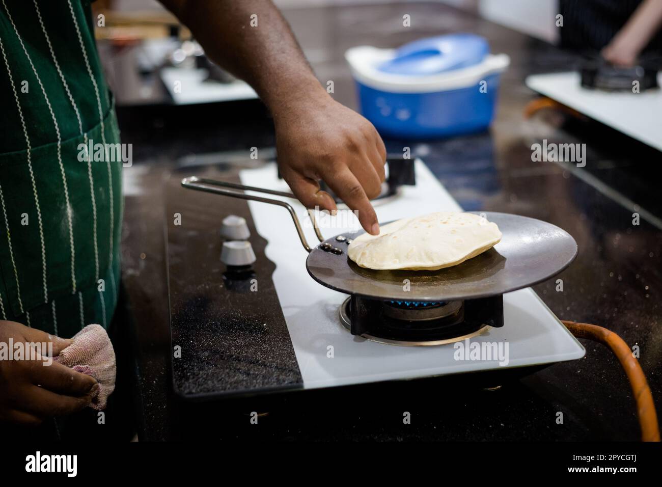 Traditional way of preparing indian food, making roti bread. Picture of ...