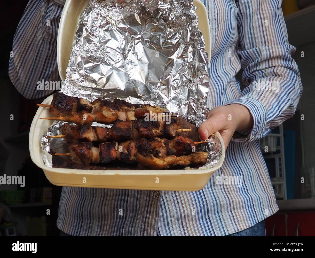 Grilled meat in disposable packaging and aluminum foil from the ...