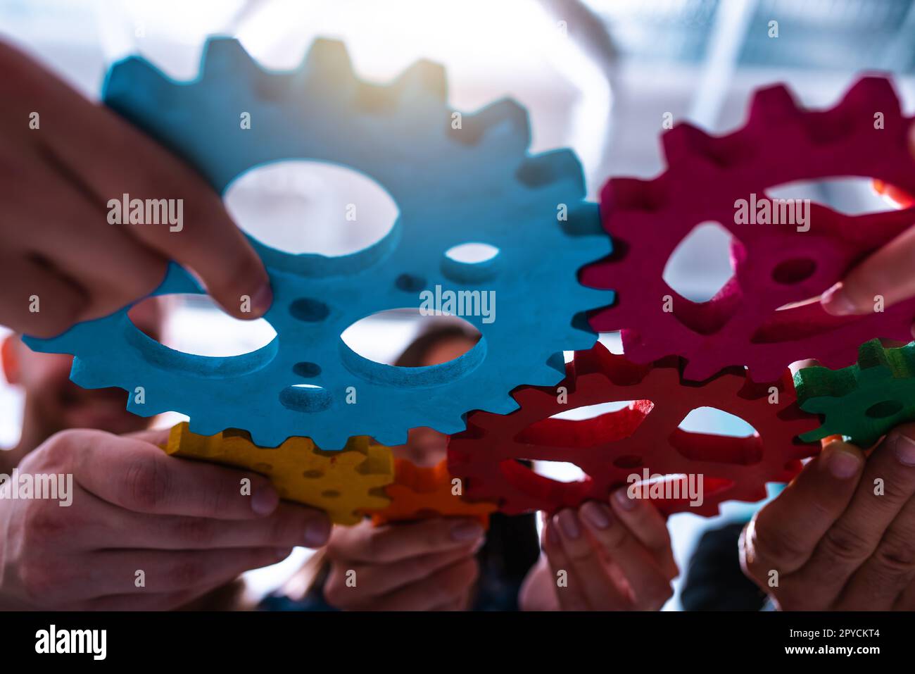 Teamwork of business people work together and combine pieces of gears ...
