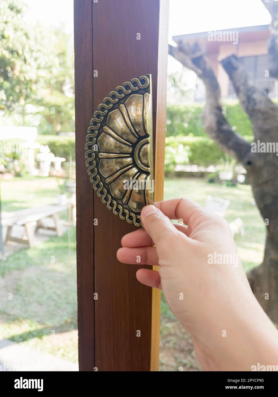 Hand on metal door holder Stock Photo - Alamy