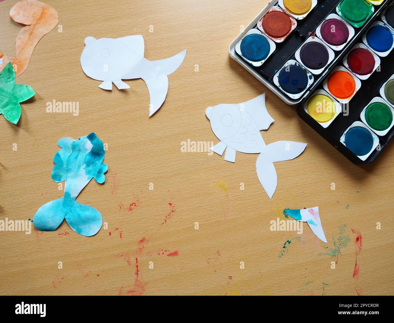 Desktop with drawing tools. A set of watercolor paints. Paper-cut ...