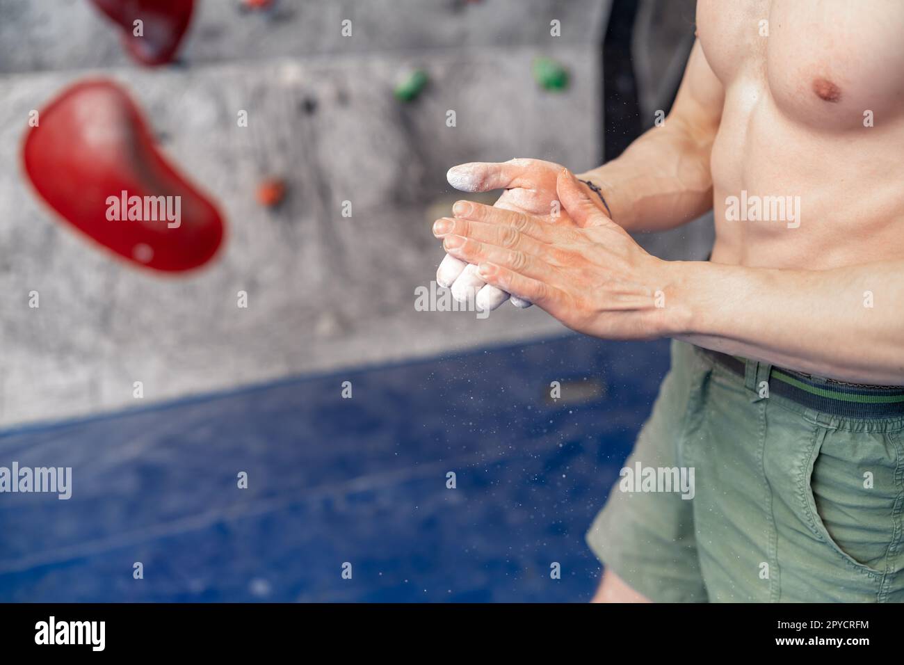 climbing magnesium on the hands of an athlete in a bouldering center ...