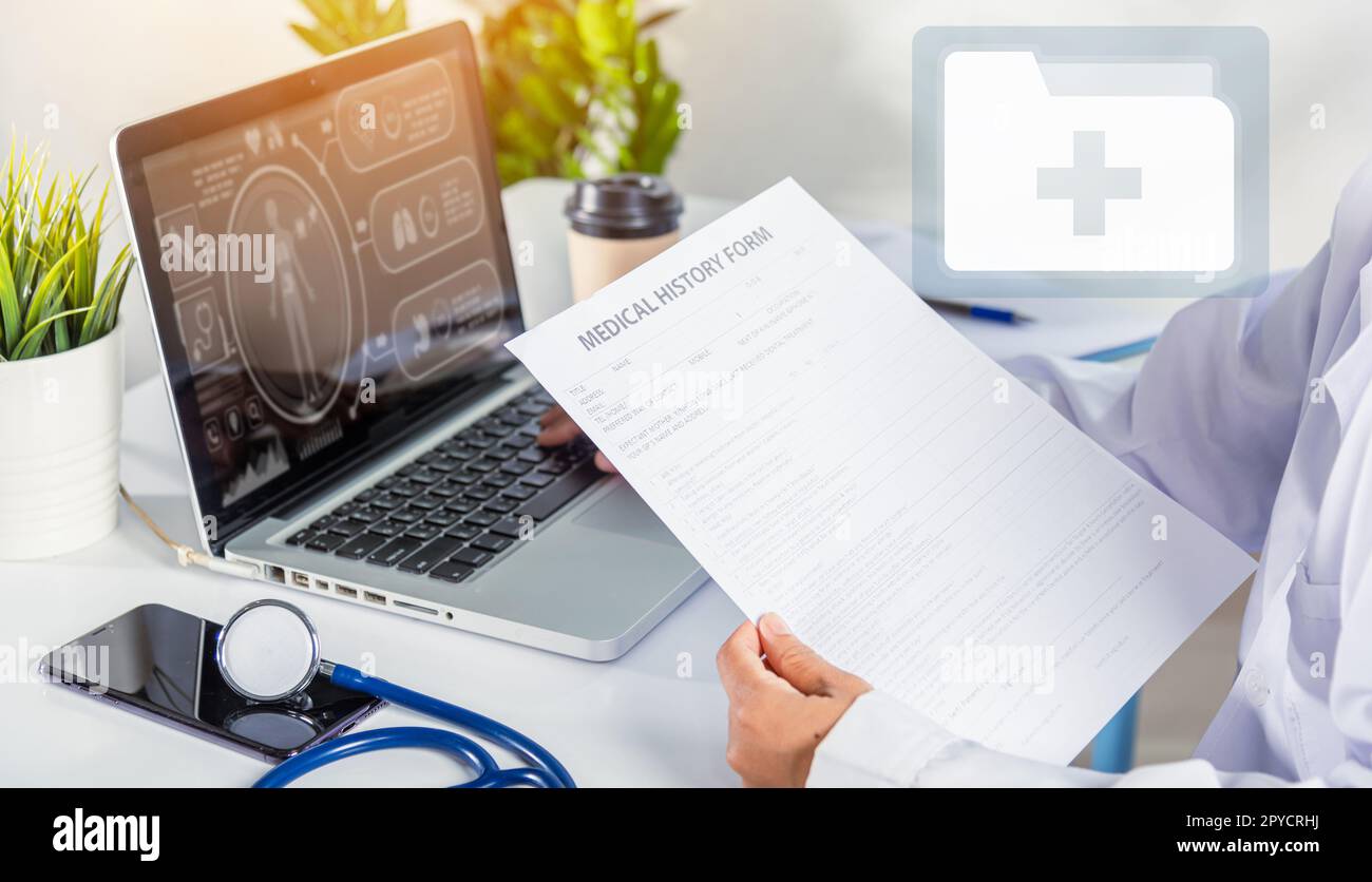 Doctor typing information of patient prescription from paperwork ...