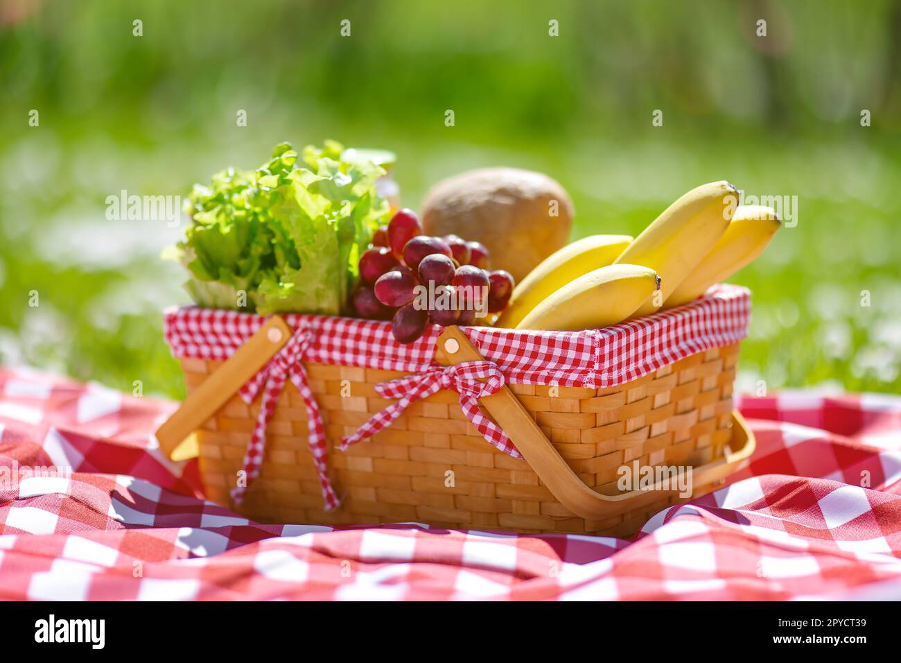Wicker basket with food standing on the picnic blanket in nature Stock ...