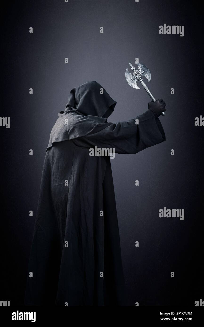 Figure in hooded cloak with axe over dark misty background Stock Photo ...