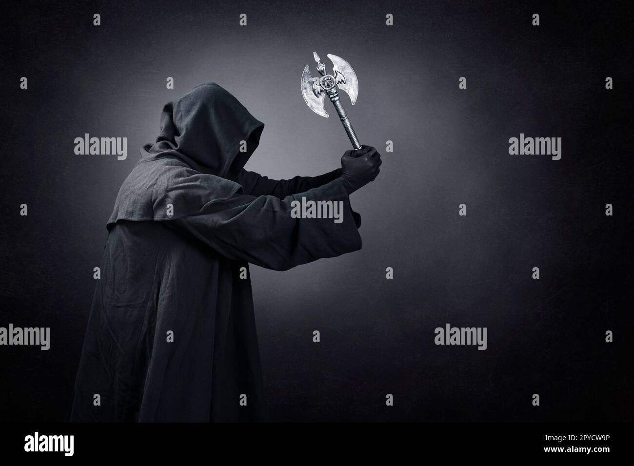 Figure in hooded cloak with axe over dark misty background Stock Photo ...