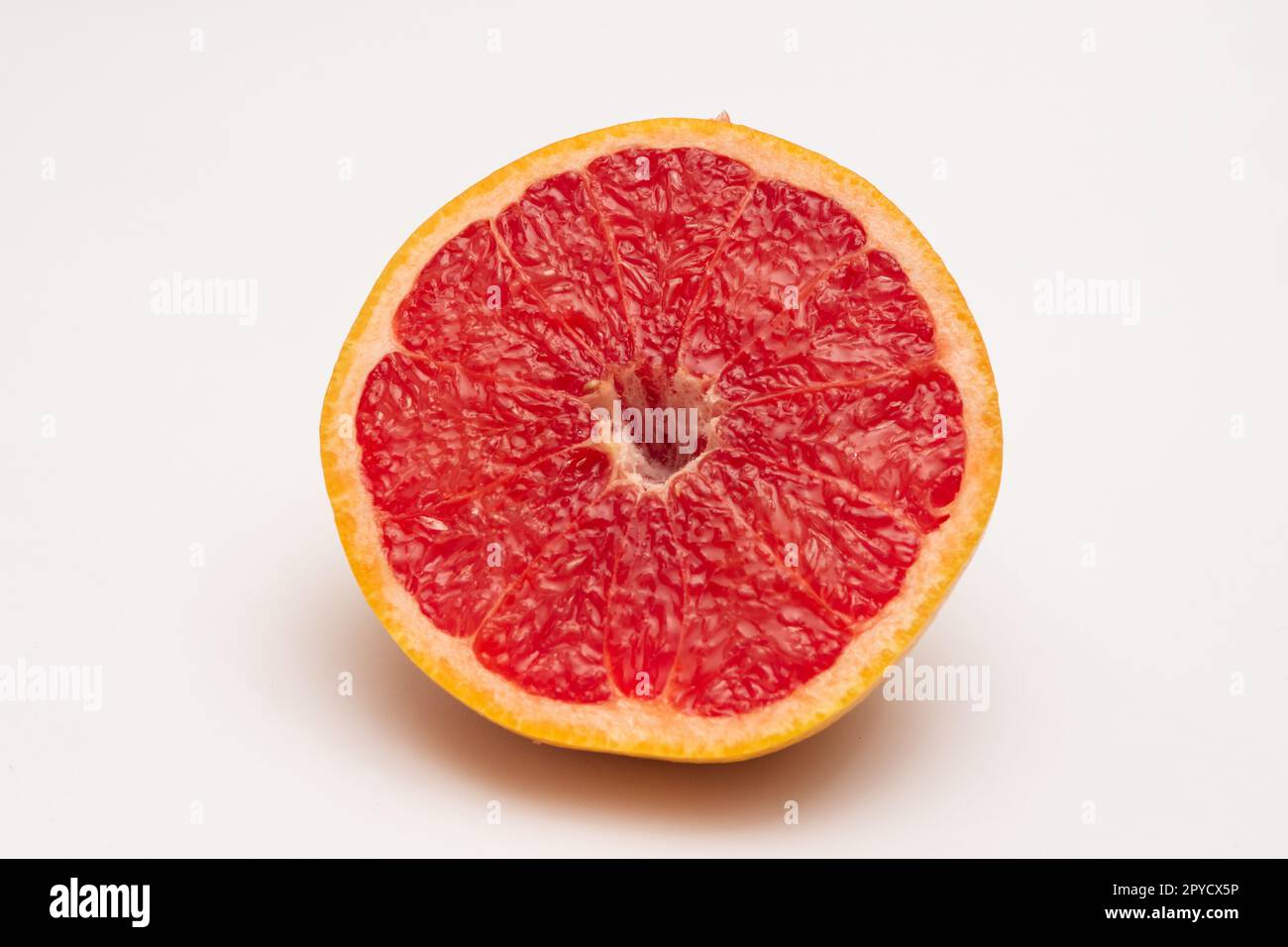 Sliced side of a grapefruit with red pulp isolated on a white ...
